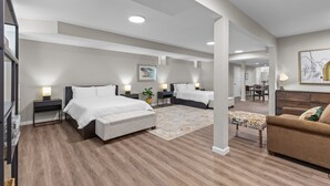 Quarto moderno com duas camas, um sofá e um espaço para refeições.