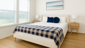 Quarto com uma cama, duas mesas de cabeceira, uma janela e um quadro na parede.