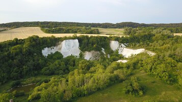 Paisagem com falésias brancas, vegetação densa e um rio.