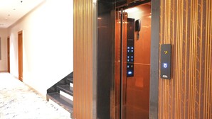 Um elevador com painel de controle e telefone.
