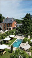 Uma casa grande com piscina, área de estar externa e jardim.