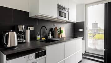 Apartamento, 3 quartos, cozinha | Cozinha privada | Um frigorífico, um micro-ondas, uma placa de cozinha