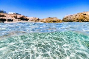 Visão nítida de uma costa rochosa com águas calmas.