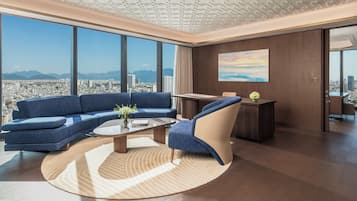 Uma sala de estar moderna com vista para a cidade, um sofá, uma mesa de centro e uma poltrona.