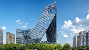 Um hotel moderno com um design angular marcante, vários andares e céu claro.