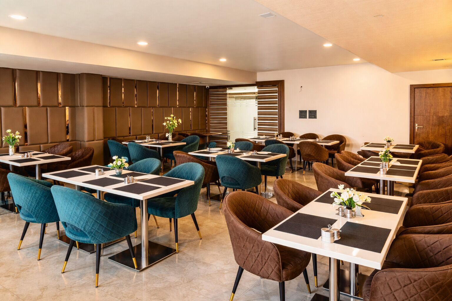 Uma sala de conferências de hotel com várias mesas e cadeiras, design de interiores moderno e uma janela grande.