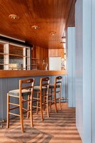 Uma área de bar com cadeiras de madeira e balcão.