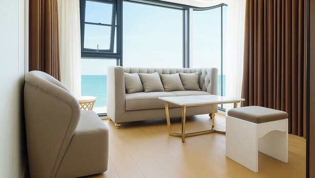 Uma sala de estar moderna com um sofá, uma mesa de centro e um banquinho.