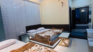 Quarto moderno com duas camas, um guarda-roupa e um ventilador de teto.