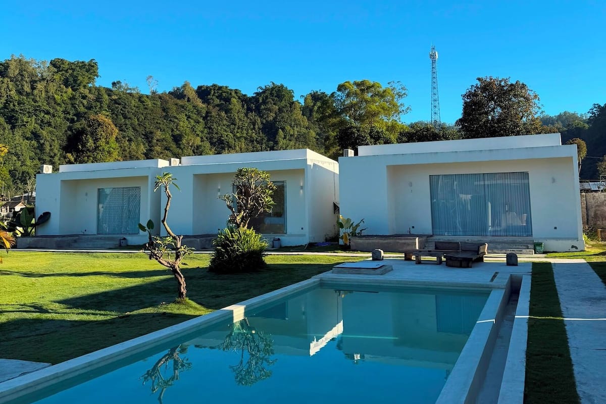 Uma villa moderna com piscina, relvado bem cuidado e vista desobstruída da floresta circundante.