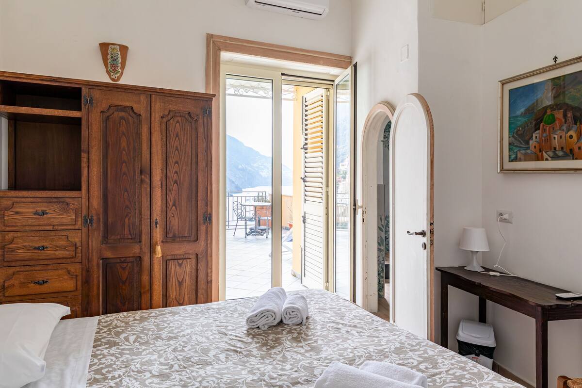 Quarto com cama, guarda-roupa de madeira e um quadro na parede.