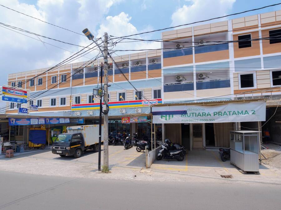 Um edifício com vários andares, com área comercial no térreo, incluindo um posto de gasolina e uma loja chamada "dil Home".