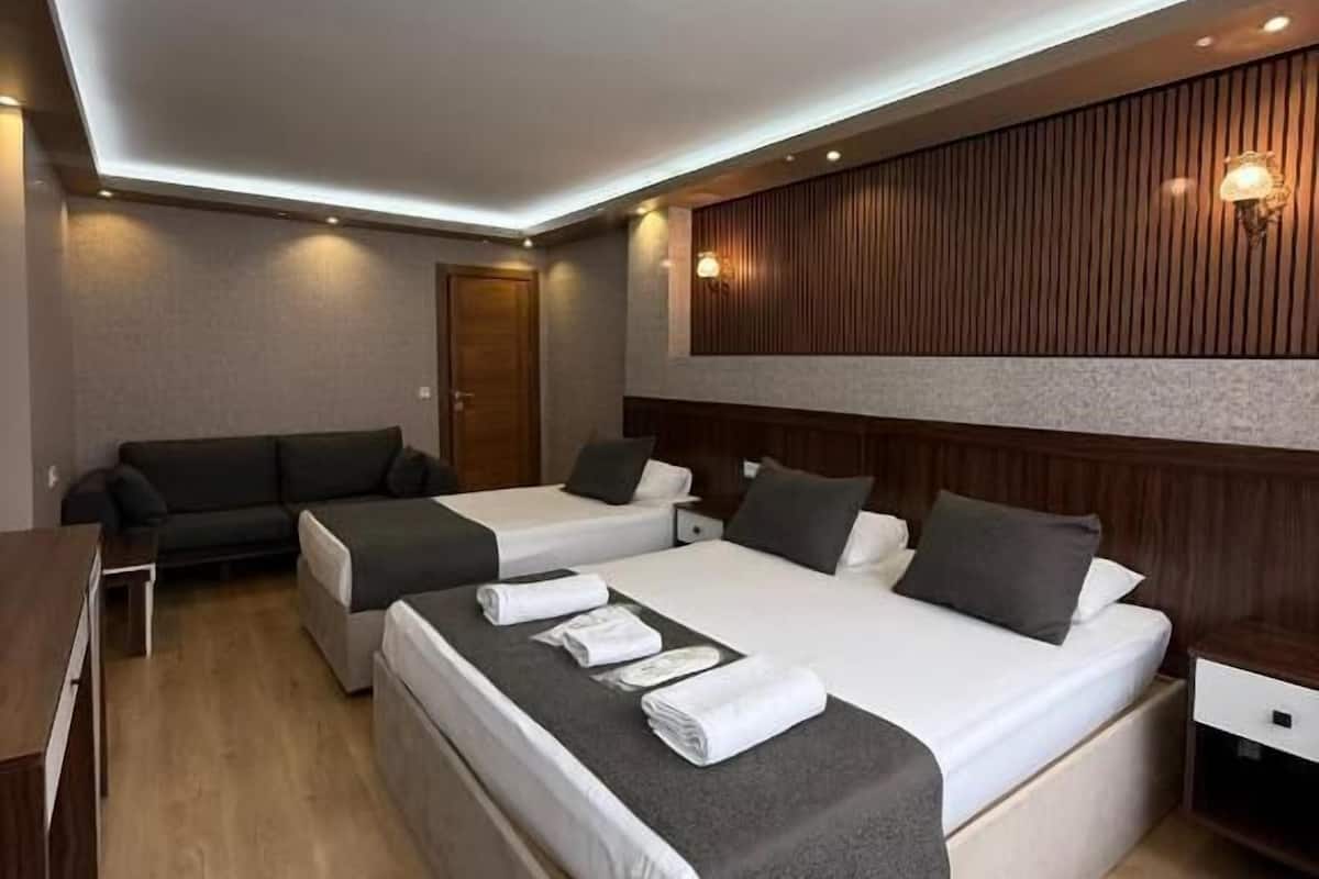 Quarto de hotel moderno com uma cama grande, um sofá e uma escrivaninha.