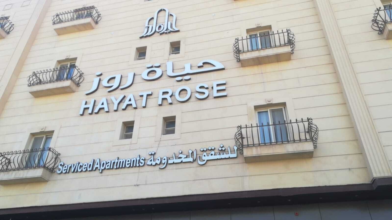 Um edifício com varandas e um letreiro que diz "Hayat Rose" e "Apartamentos Servidos".