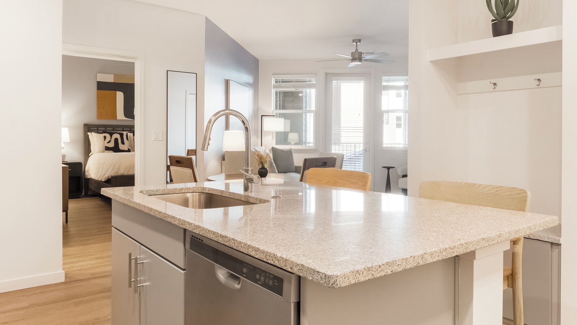 Uma cozinha moderna com bancada de granito, eletrodomésticos de aço inoxidável e lava-louças embutida.