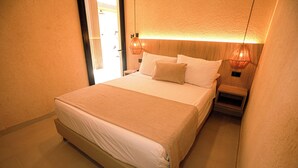 Quarto com uma cama grande, duas mesas de cabeceira e cabeceira de madeira.
