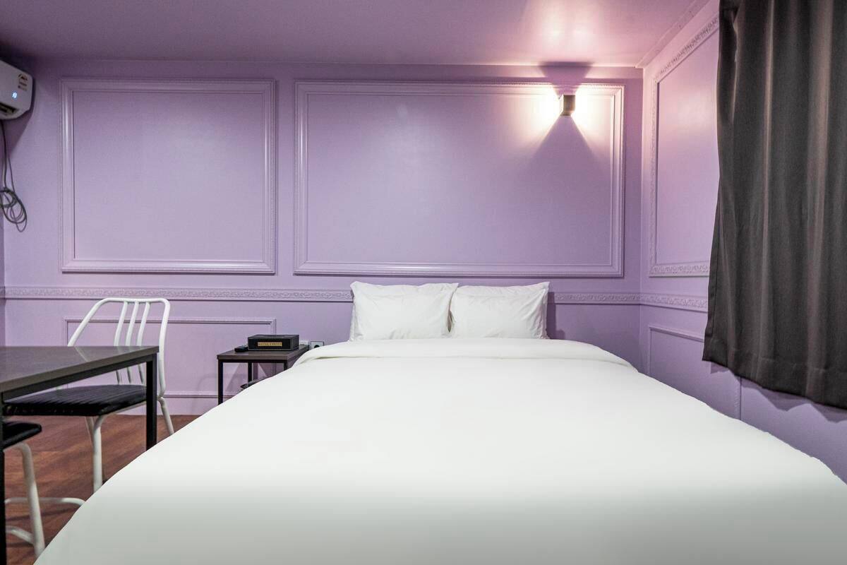 Um quarto com uma cama, uma mesa e uma cadeira.
