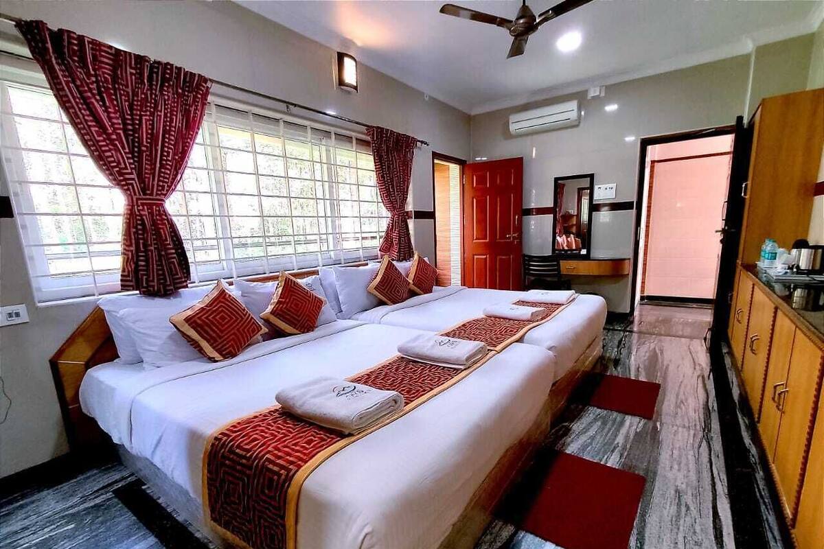 Quarto de hotel com uma cama grande, um guarda-roupa, um espelho e uma porta.