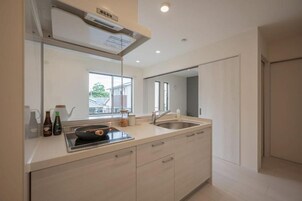 Cozinha moderna com uma ilha grande, eletrodomésticos de aço inoxidável e uma janela que proporciona luz natural.