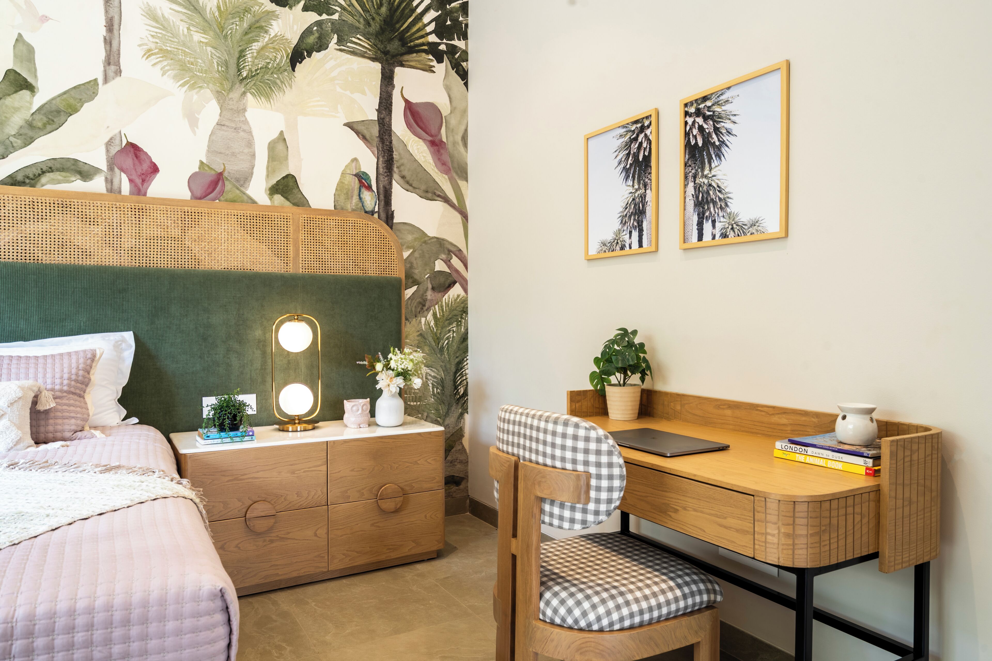 Quarto com cama, escrivaninha, cadeira, espelho e obras de arte nas paredes.