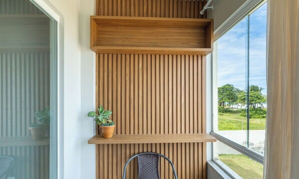 Quarto com parede de ripas de madeira, uma planta em vaso e uma cadeira.