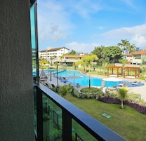 Uma área de piscina com várias piscinas, espreguiçadeiras e um gazebo.