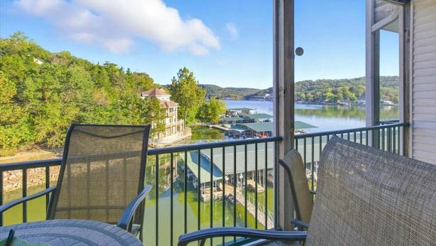 Varanda com vista para um lago e edifícios circundantes.