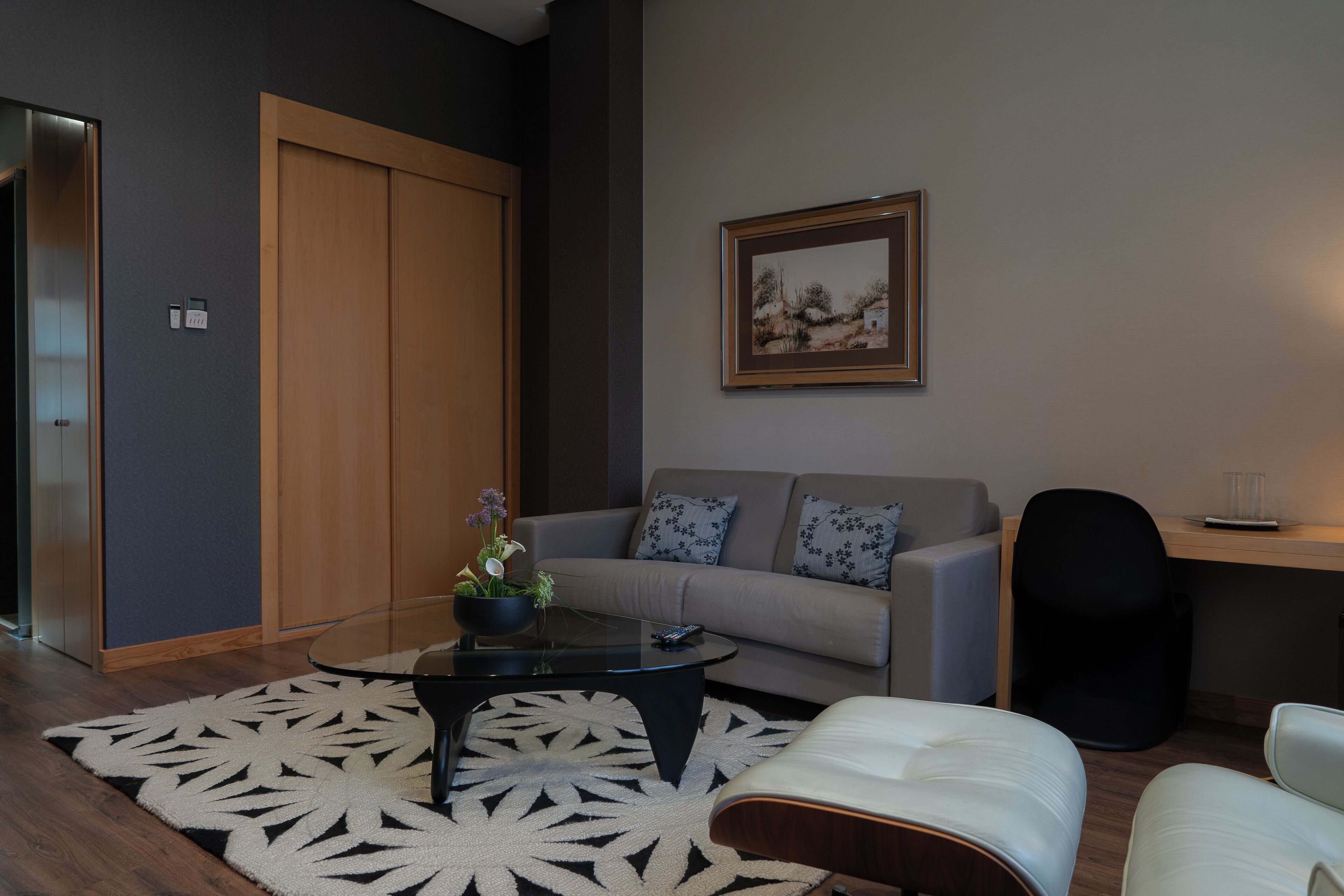 Uma sala de estar moderna com um sofá, uma mesa de centro e um tapete grande.