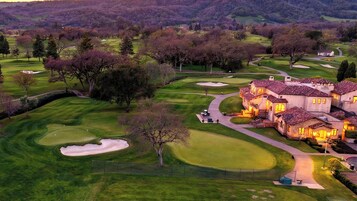 Um campo de golfe com um clube, apresentando vários edifícios e paisagem bem cuidada.