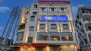 Um edifício de vários andares com uma placa chamativa da 'fabHOTELS'.