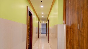 Um corredor com portas de madeira e paredes brancas.
