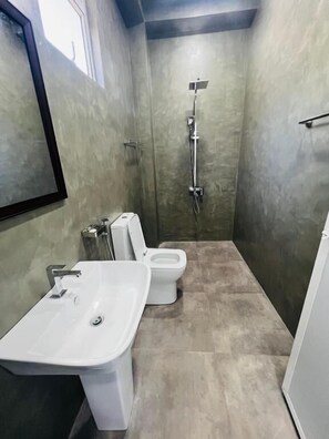 Um secador de cabelo, toalhas fornecidas, sabão, champô 