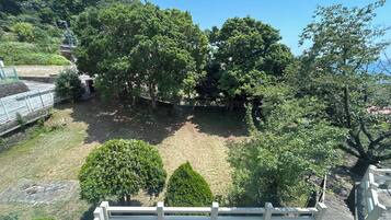 Um espaço ao ar livre cercado, com árvores e um caminho pavimentado.