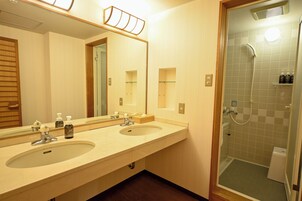 Quarto Familiar | Casa de banho | Uma combinação polibã/banheira, um secador de cabelo, chinelos, um bidé