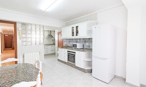 Um frigorífico, um micro-ondas, um forno, uma cafeteira/bule 