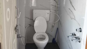 Um banheiro pequeno com vaso sanitário, chuveiro e pia.