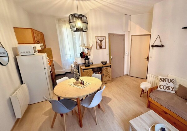Um espaço compacto com área de refeições, cozinha compacta e um canto de estar acolhedor.