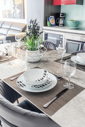 Uma sala de jantar com uma mesa posta para quatro pessoas, incluindo pratos, tigelas e talheres.