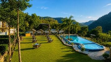 Um resort com piscina, área de estar externa e vista para as colinas ao redor.