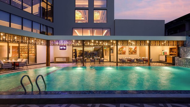 Um hotel moderno com piscina, área de estar ao ar livre e bar.