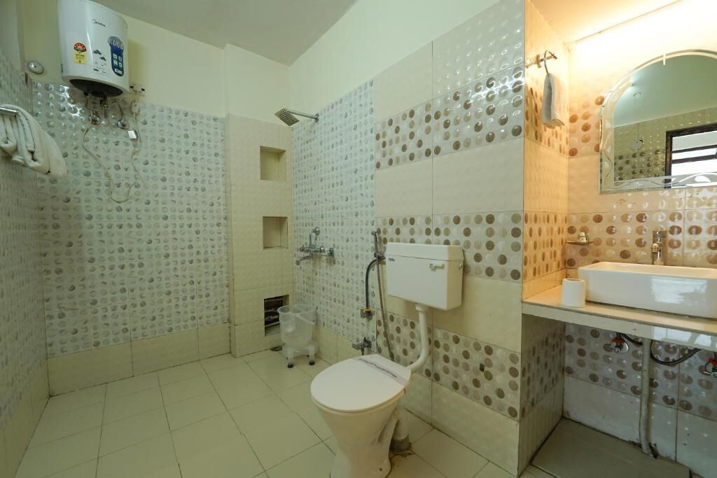 Casa de banho com sanita, lavatório e chuveiro.