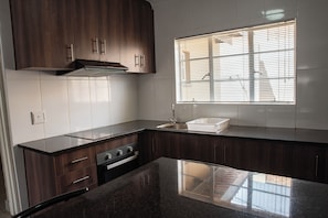 Apartamento luxo, 2 quartos | Cozinha privada | Geladeira, micro-ondas, fogão, talheres/pratos/utensílios de cozinha