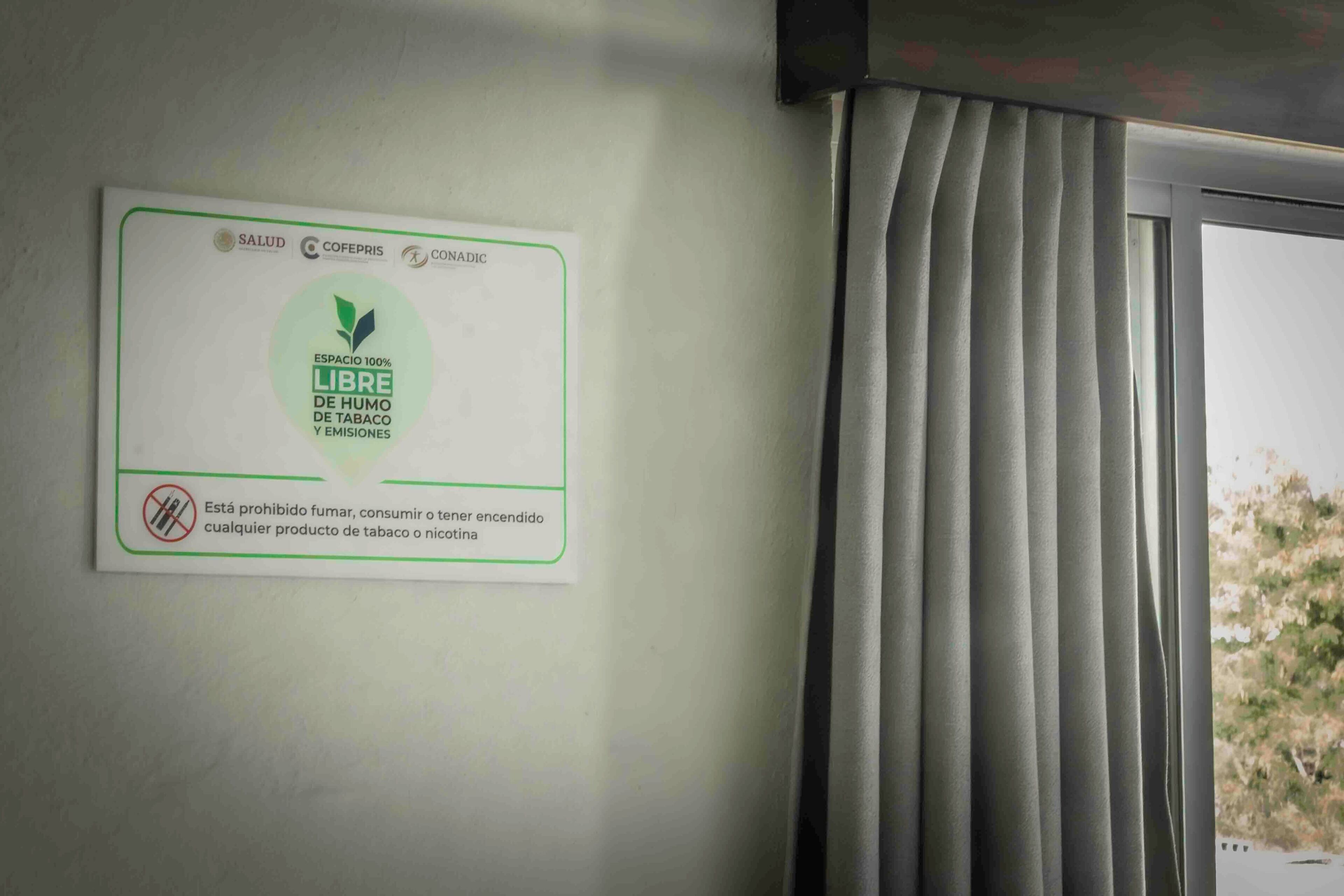 Placa na parede indicando um ambiente livre de fumo e tabaco.