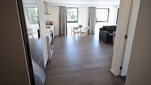 Uma cozinha moderna com forno embutido e um espaço de refeições com mesa e cadeiras.