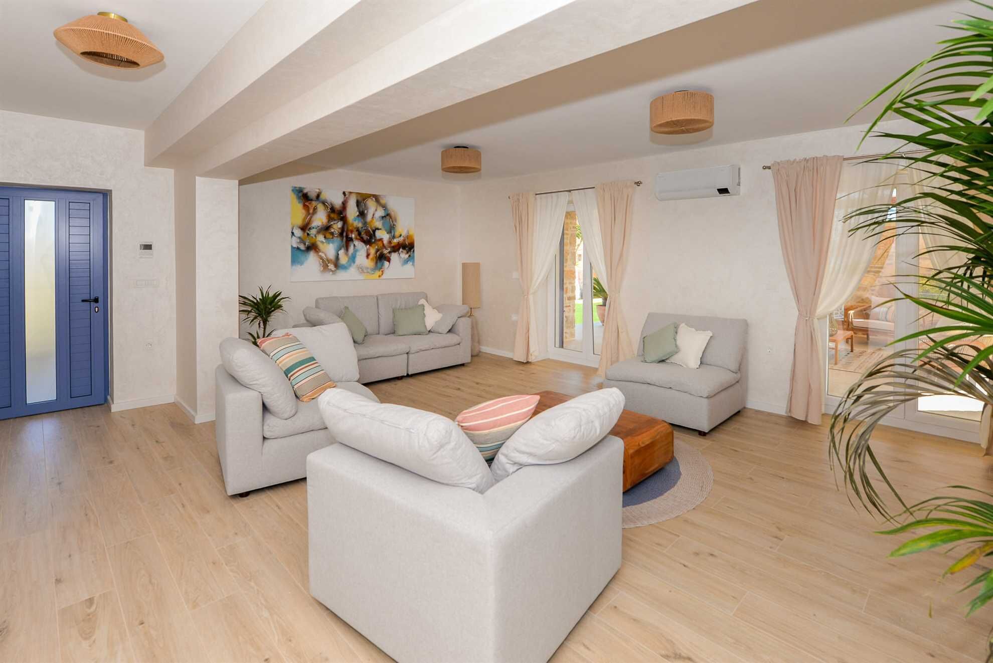Uma sala de estar com dois sofás, uma mesa de centro e um quadro na parede.