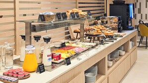 Um buffet de café da manhã com diversos alimentos e acompanhamentos.