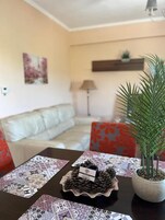 Uma mesa de jantar com um arranjo decorativo, um vaso de planta e uma prateleira na parede com uma planta.