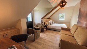 Um quarto de loft aconchegante com cama, área de estar e escrivaninha.