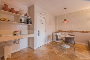 Cozinha moderna com armários brancos, forno embutido e área de refeições com mesa e cadeiras.