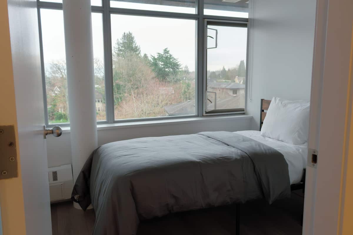 Quarto com cama, janela e porta.